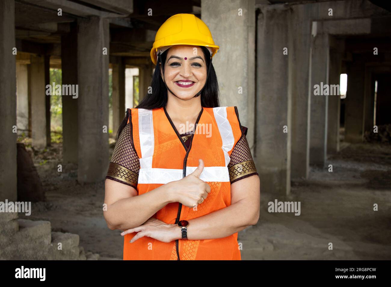 Portrait of confident Indian female civil engineer wearing helmet and ...