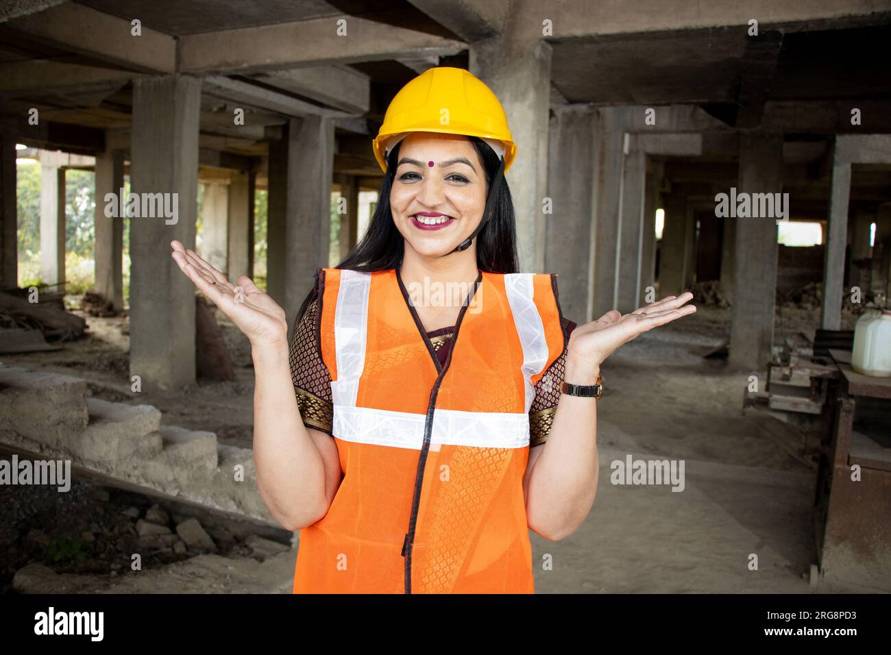 Portrait of happy beautiful Indian female civil engineer wearing helmet ...