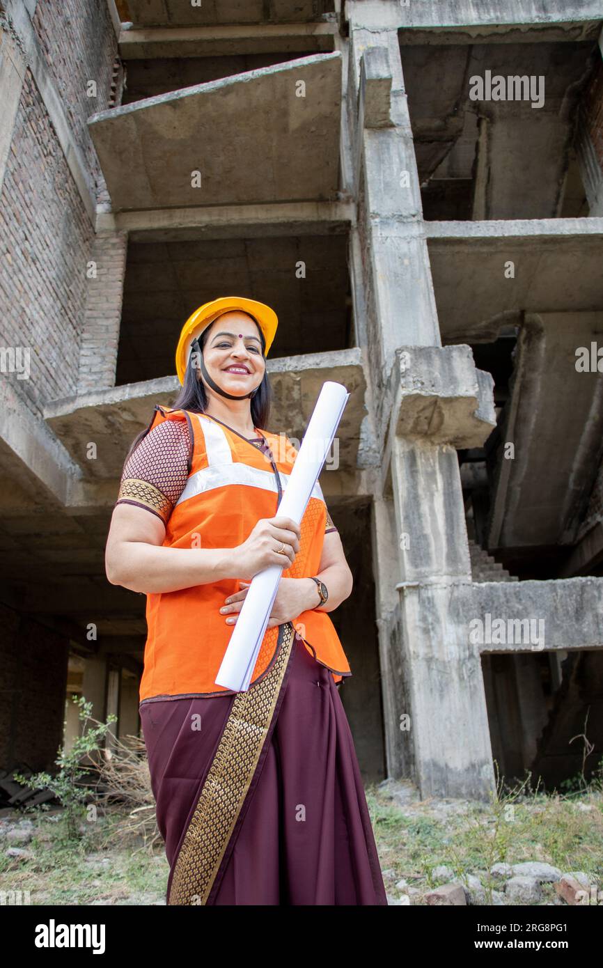 Portrait of confident young beautiful Indian female civil engineer or ...