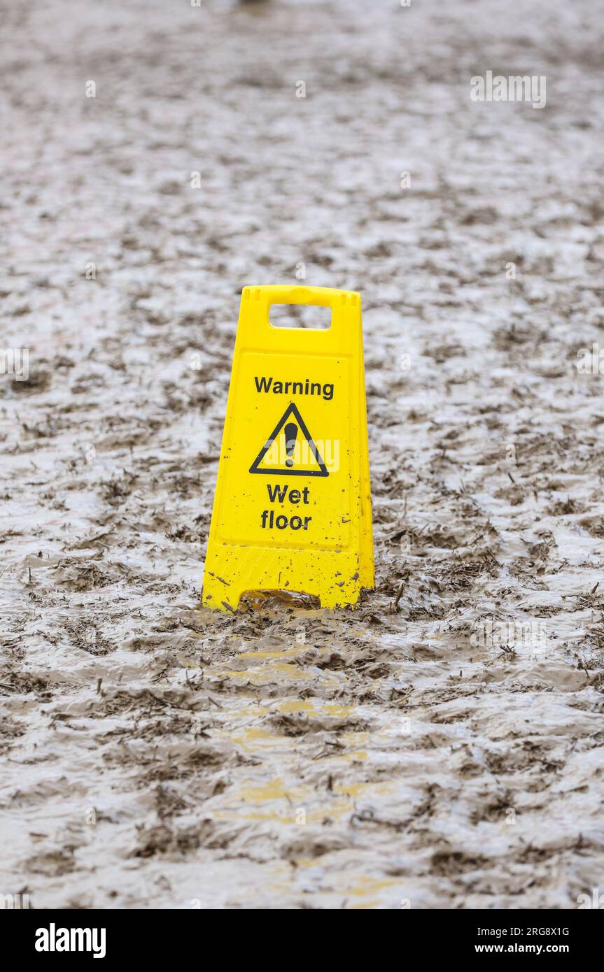 Muddy Wickham Festival 2023. Wet Floor sign placed in the mud Stock ...