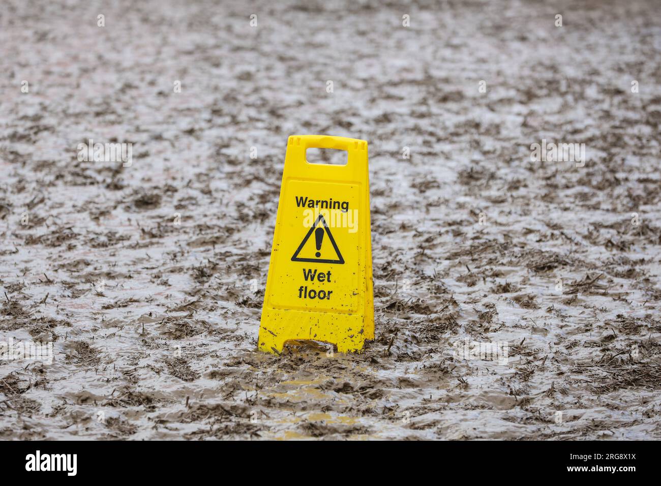 Muddy Wickham Festival 2023. Wet Floor sign placed in the mud Stock ...