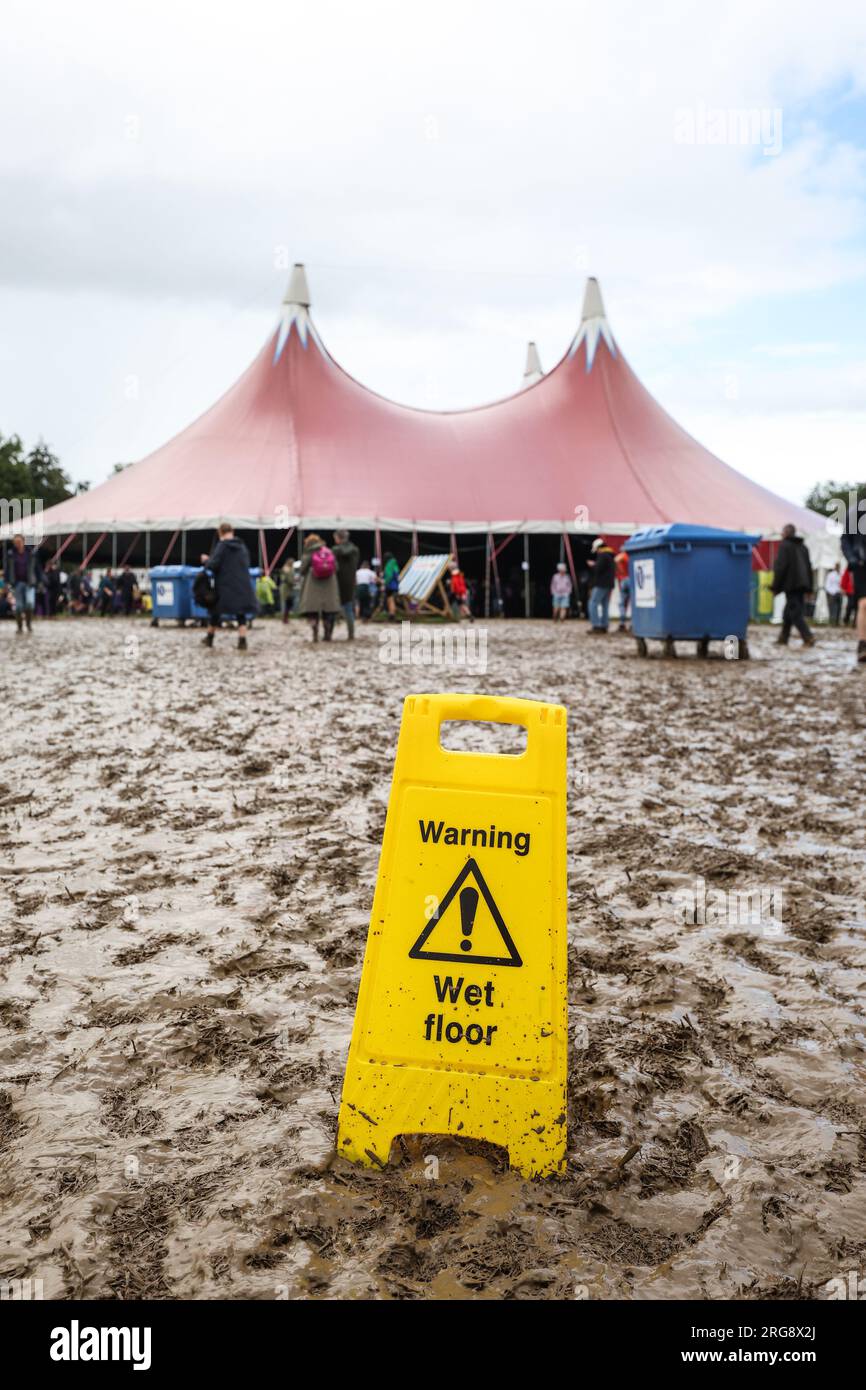 Muddy Wickham Festival 2023. Wet Floor sign placed in the mud Stock ...