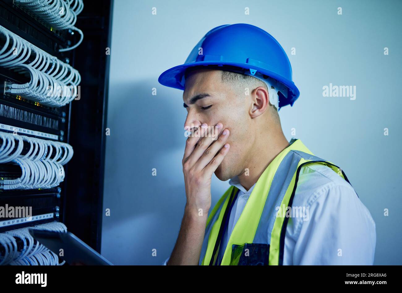 Electrician, control room with man yawning, tired with tablet and tech ...