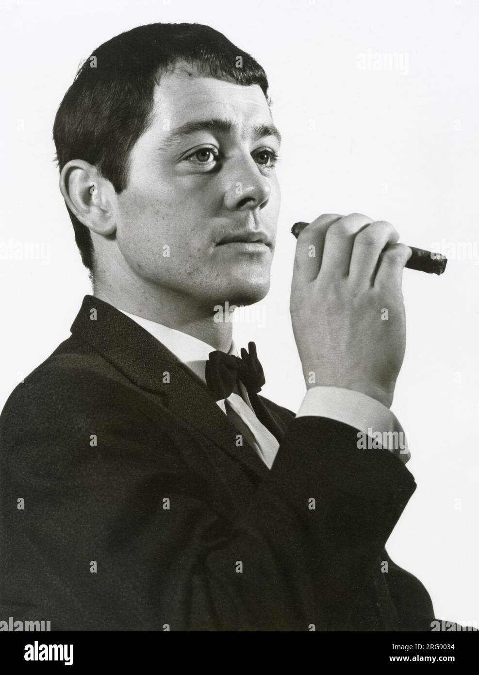 A man poses in a dinner jacket smoking a cigar Stock Photo - Alamy