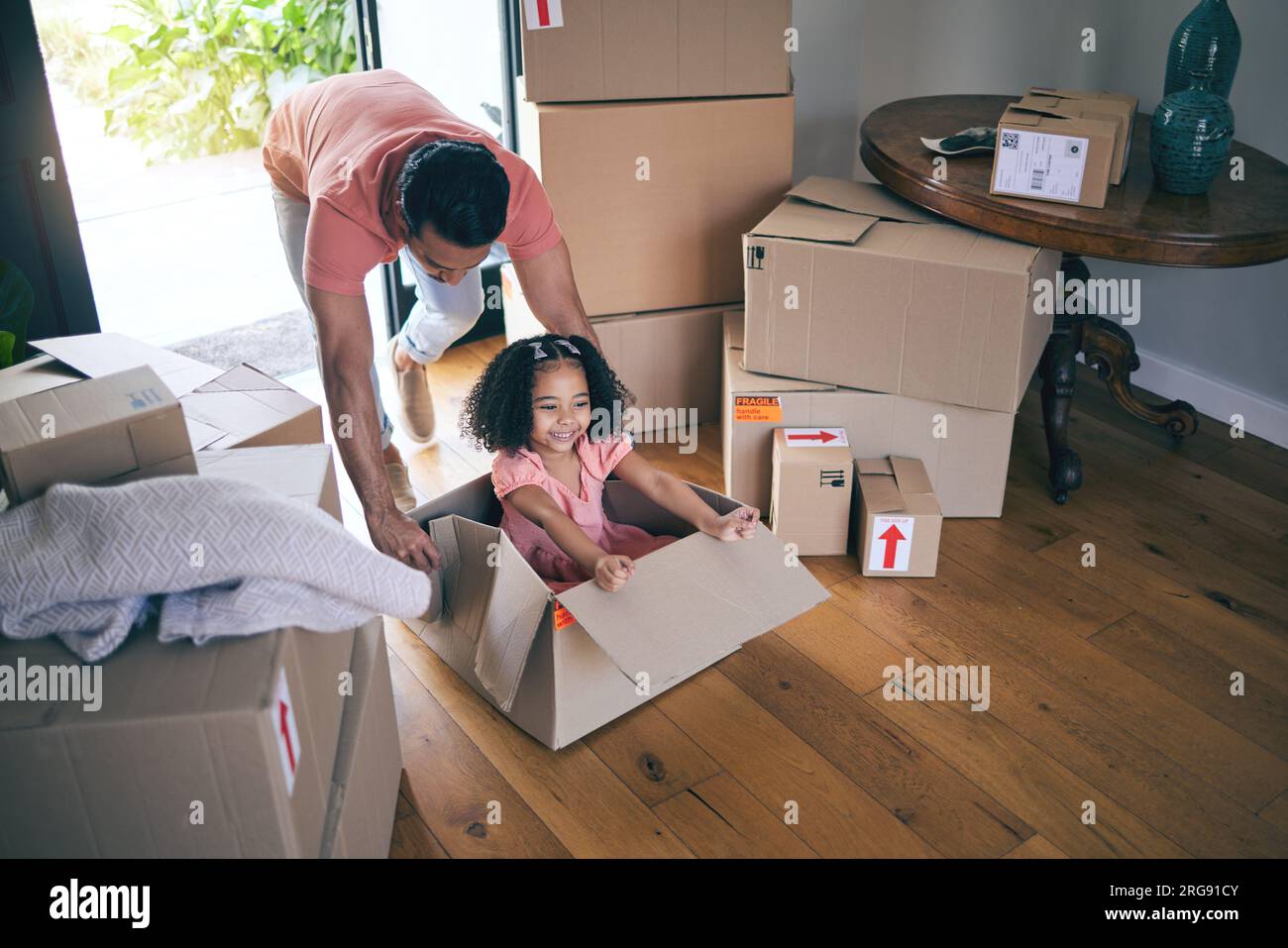 Dad, child and box in new home for games, fun and freedom on floor of ...