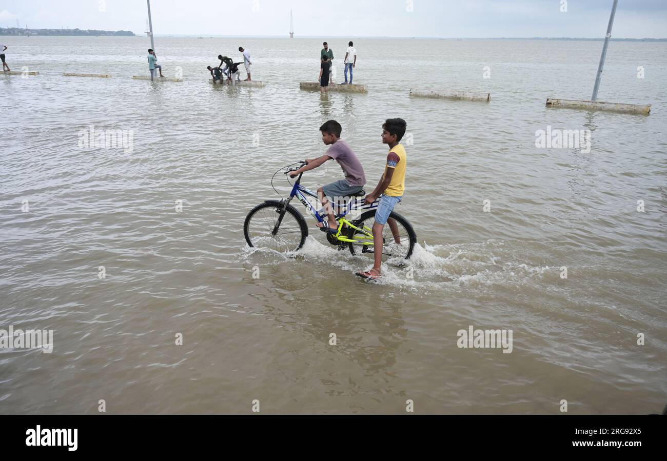 Children rides on a flooded street adjoining with holy river Ganges in ...