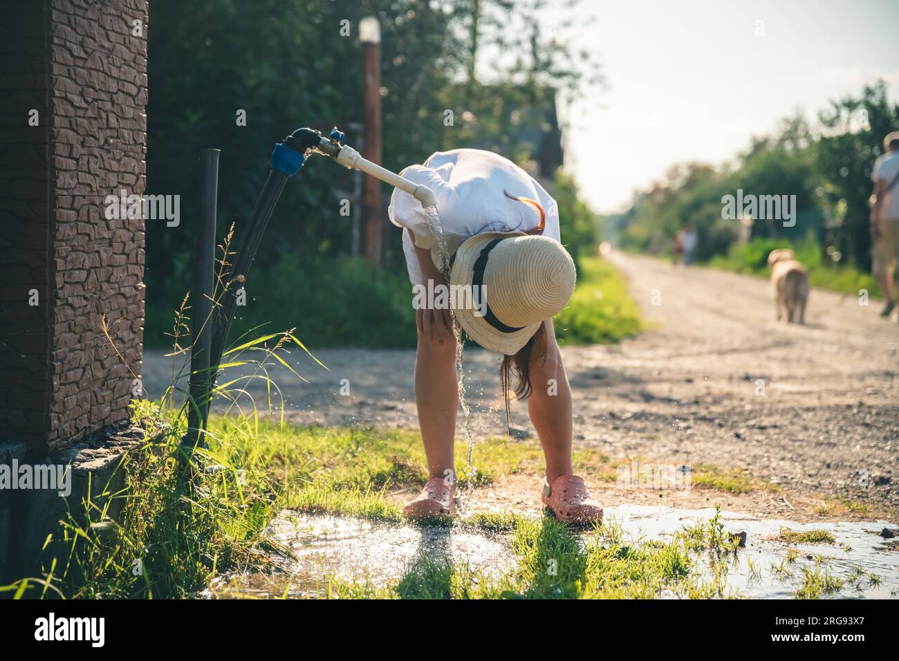 Cute girl in the village drinking tap water, country life Stock Photo ...