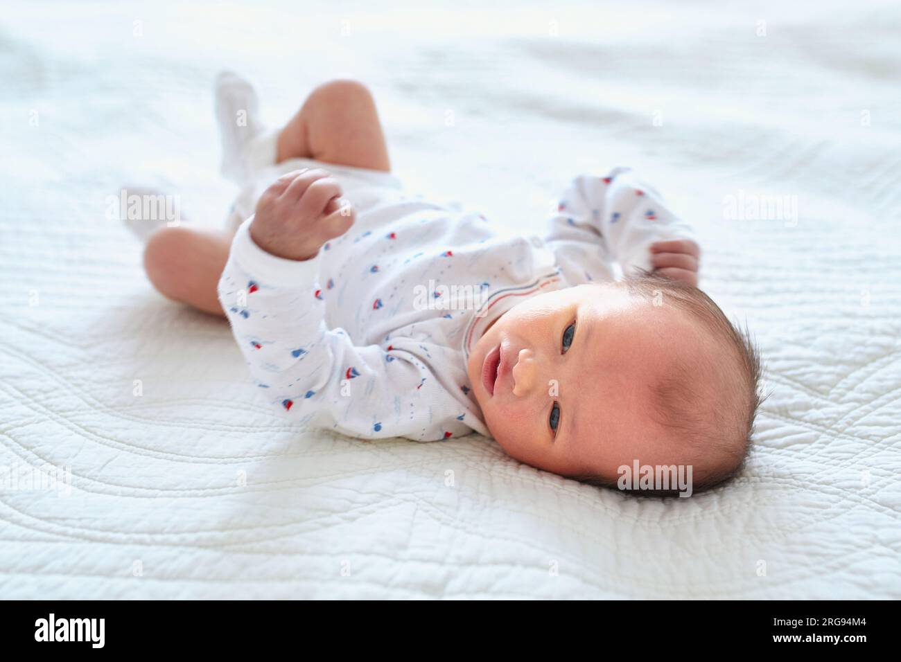Adorable newborn baby girl lying on her parents' bed at home Stock Photo - Alamy