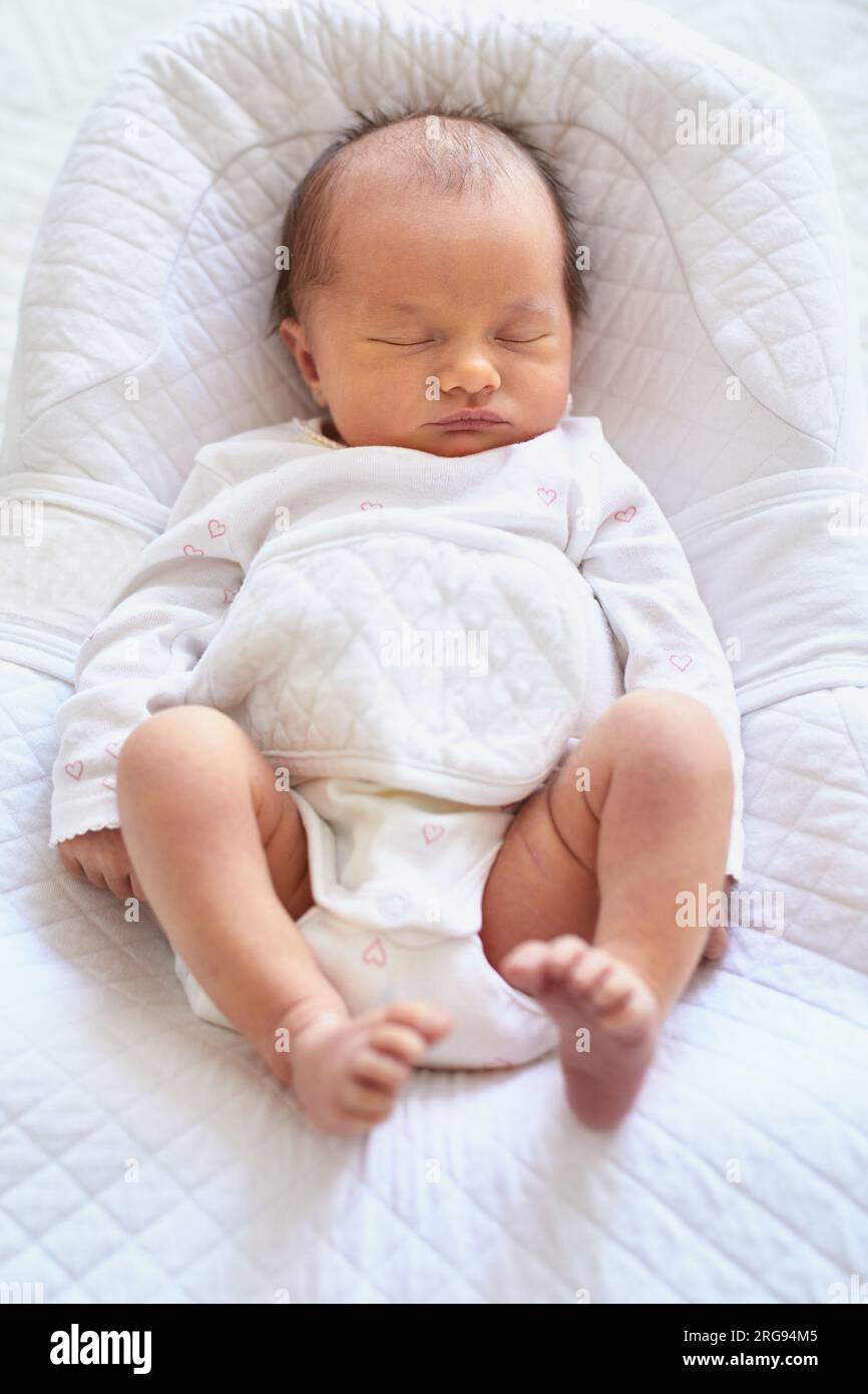 Adorable newborn baby girl sleeping in bed at home Stock Photo - Alamy