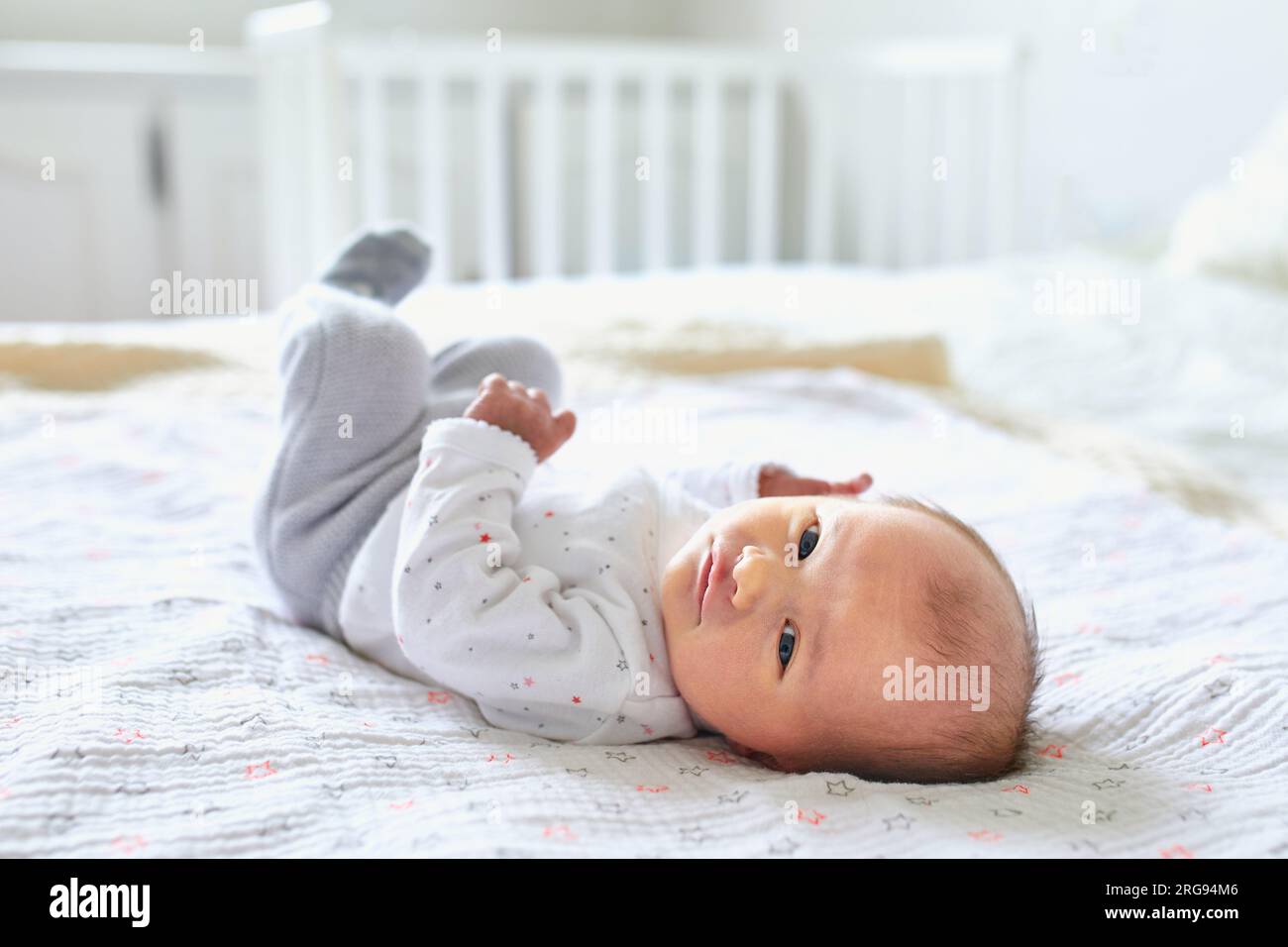 Adorable newborn baby girl lying on her parents' bed at home Stock Photo - Alamy
