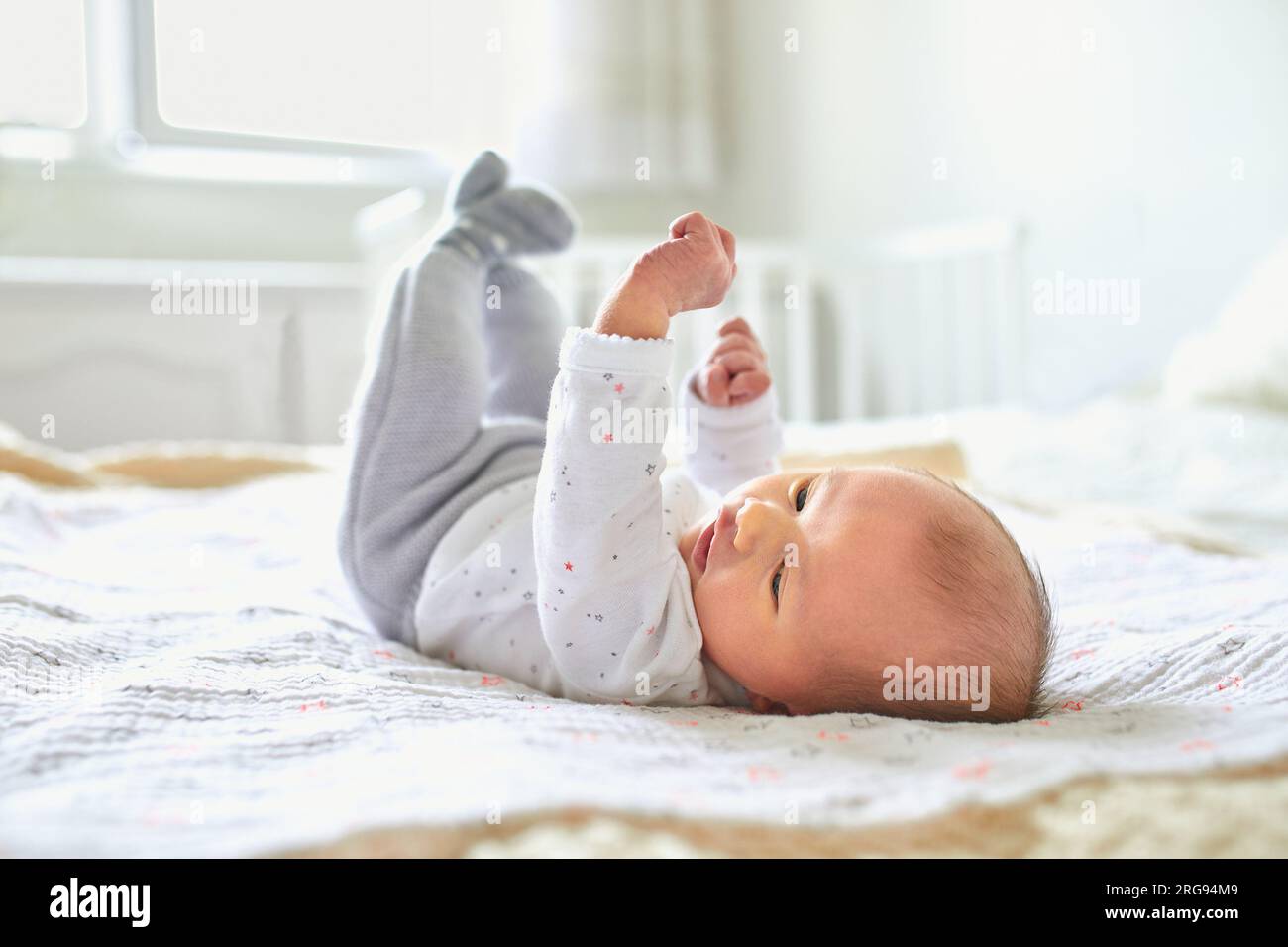 Adorable newborn baby girl lying on her parents' bed at home Stock Photo - Alamy