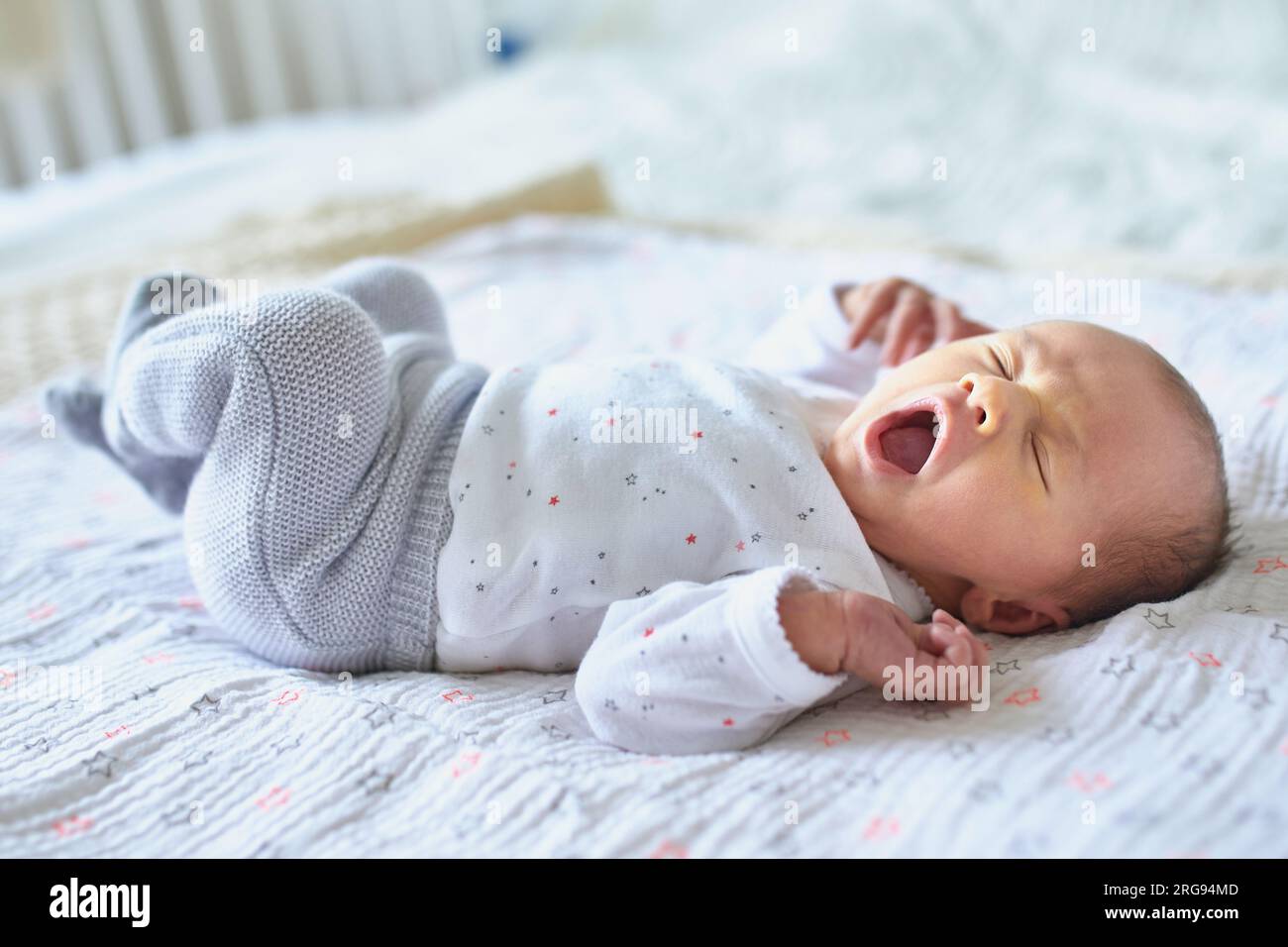 Adorable newborn baby girl sleeping and yawning in bed at home Stock Photo - Alamy