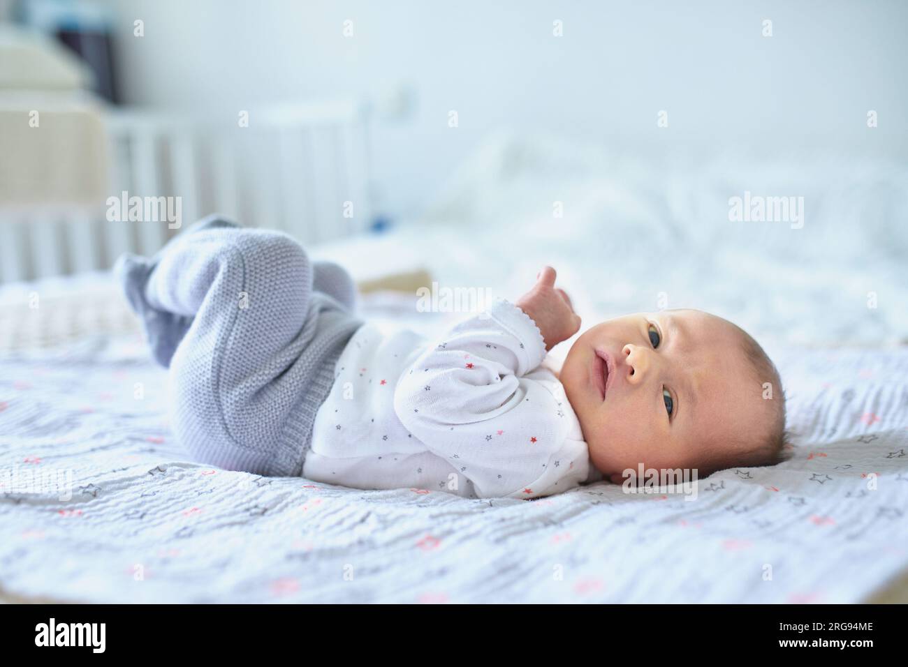 Adorable newborn baby girl lying on her parents' bed at home Stock Photo - Alamy