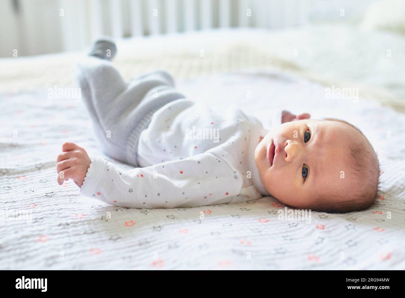 Adorable newborn baby girl lying on her parents' bed at home Stock Photo - Alamy