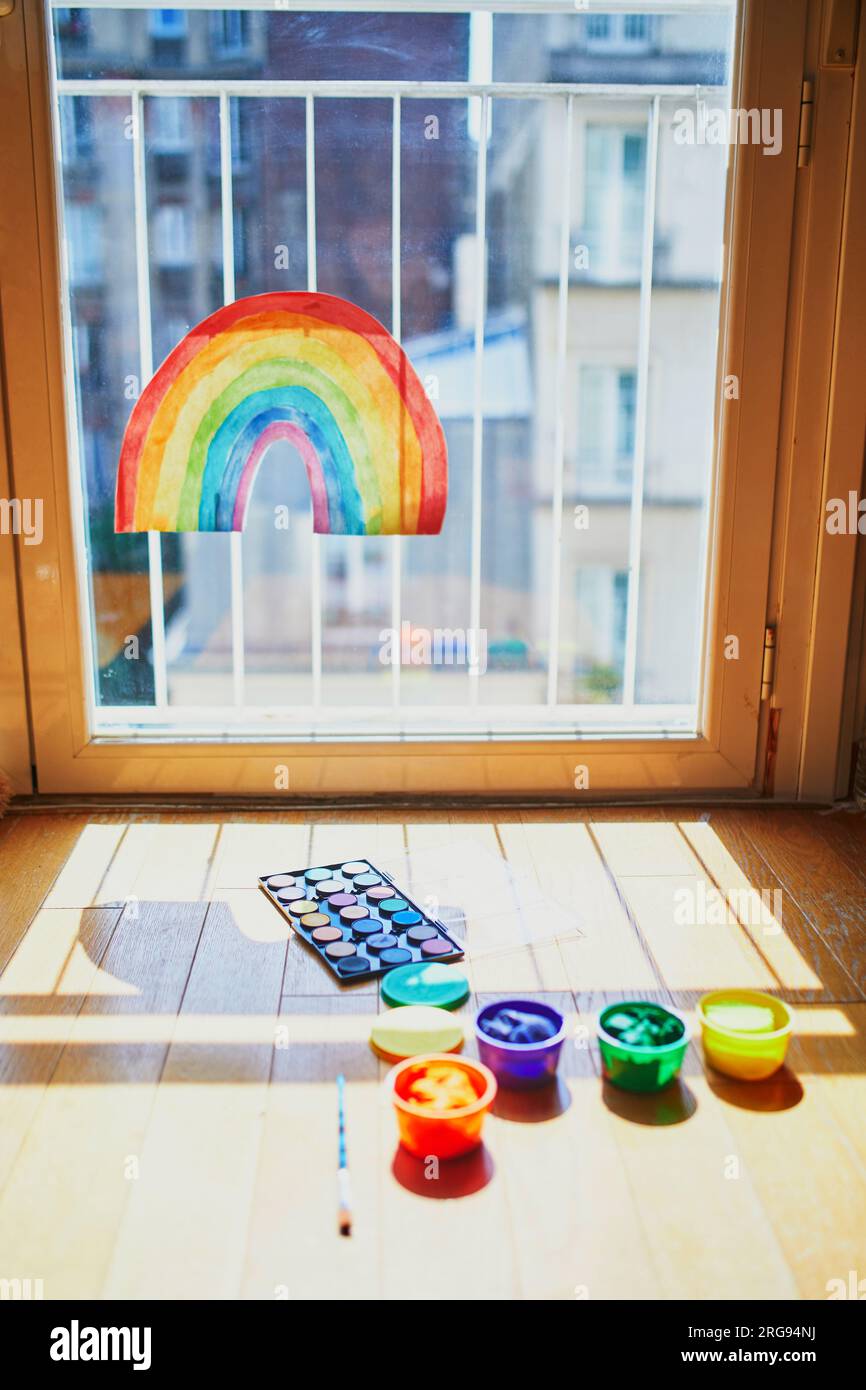 Rainbow drawing on window glass as sign of hope. Creative games for ...