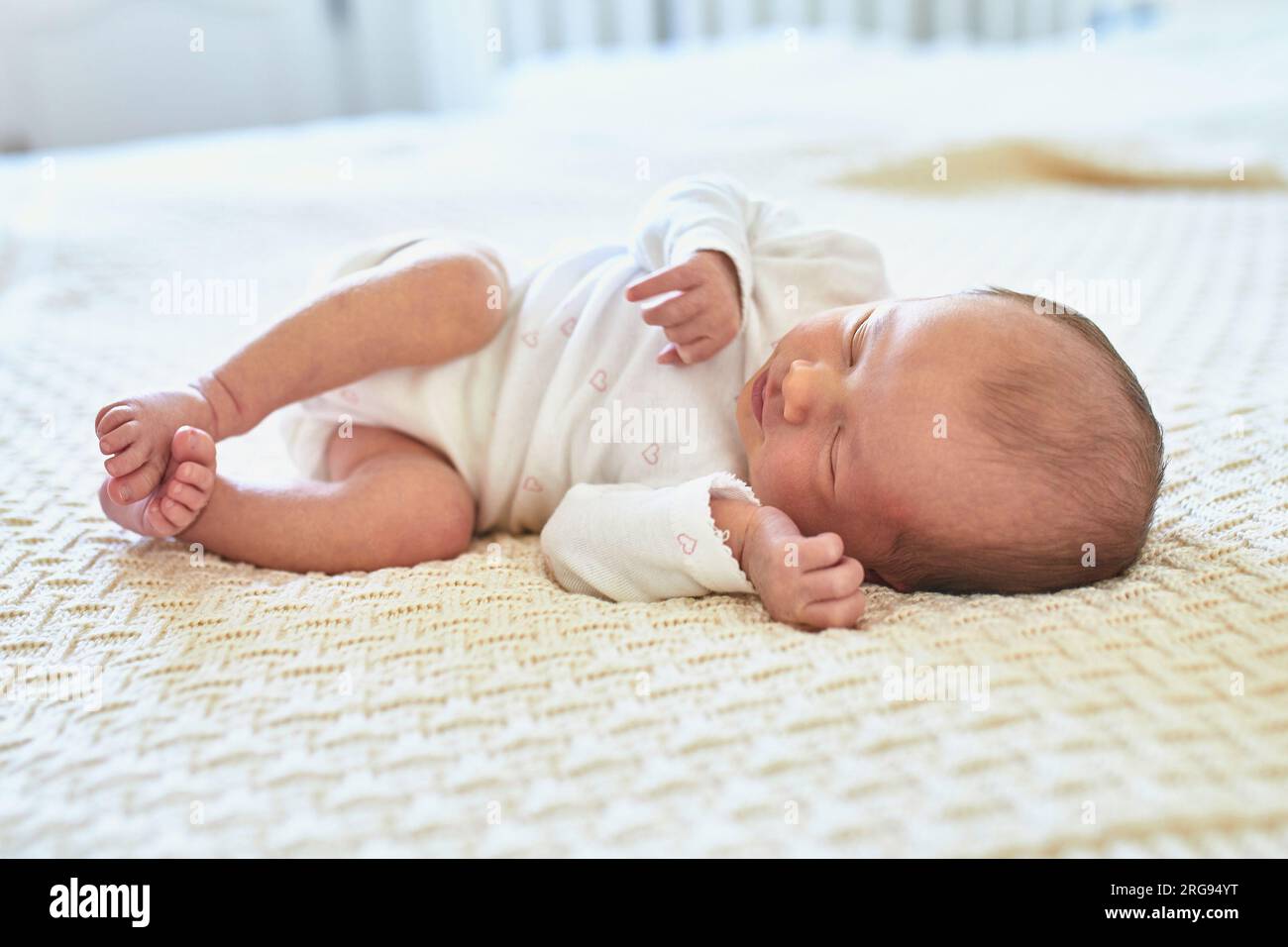 Adorable newborn baby girl sleeping in bed at home Stock Photo - Alamy