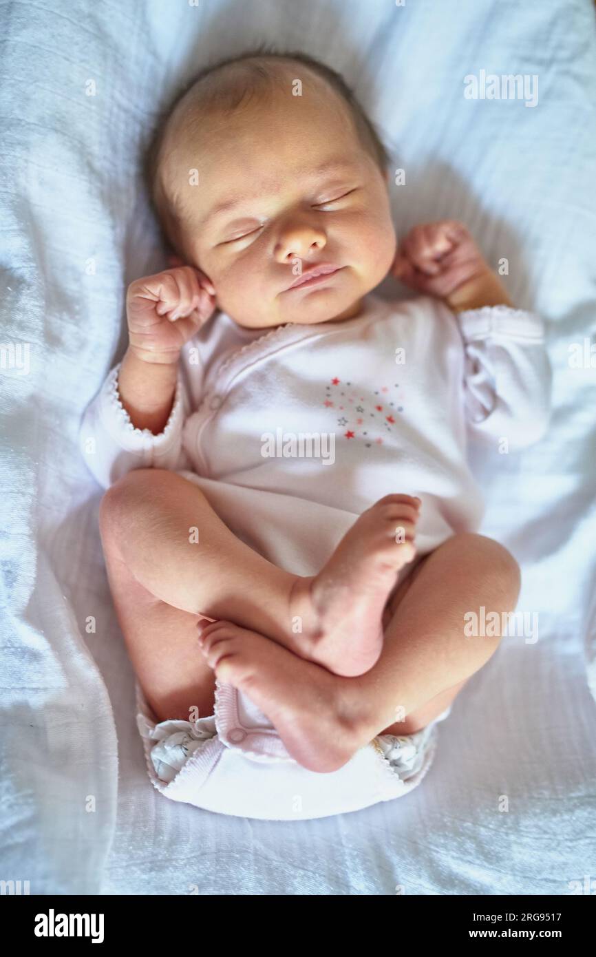 Adorable newborn baby girl sleeping in bed at home Stock Photo - Alamy