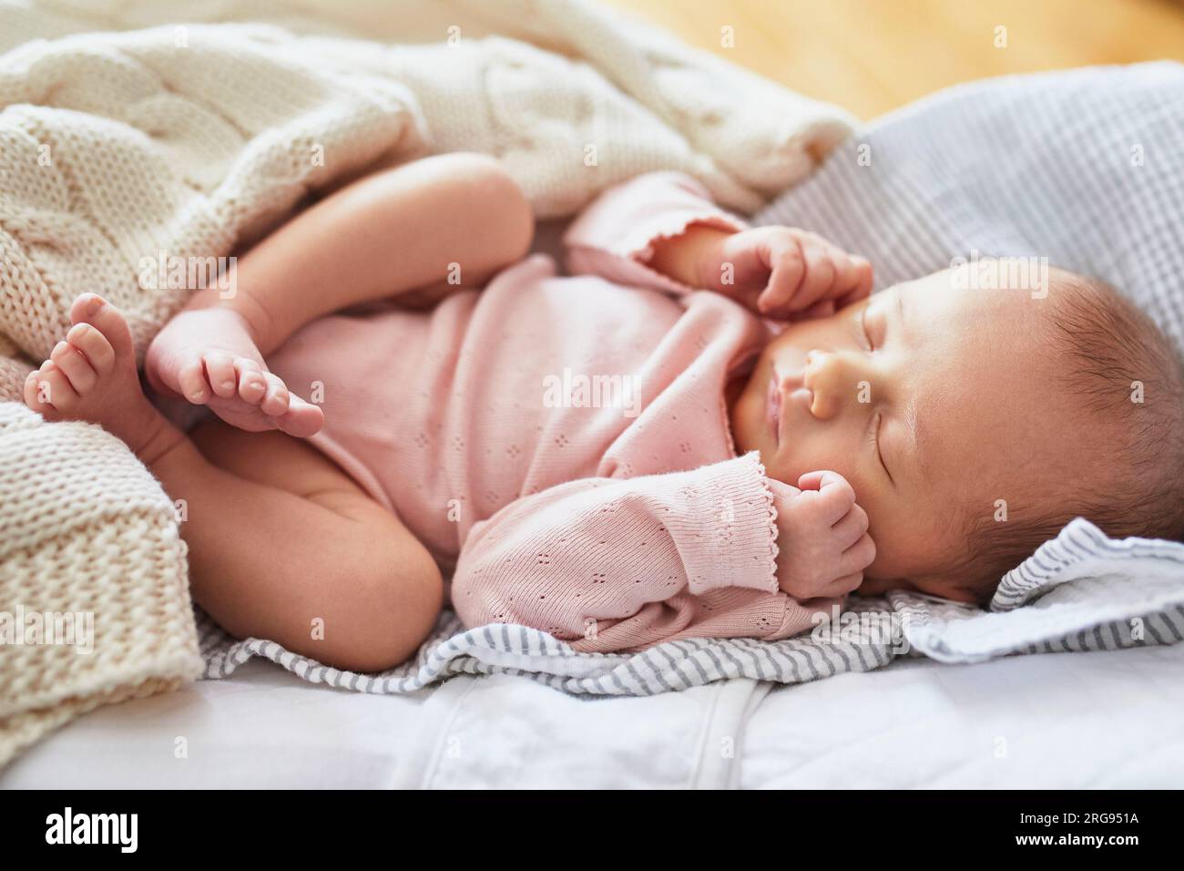 Adorable newborn baby girl sleeping in bed at home Stock Photo - Alamy