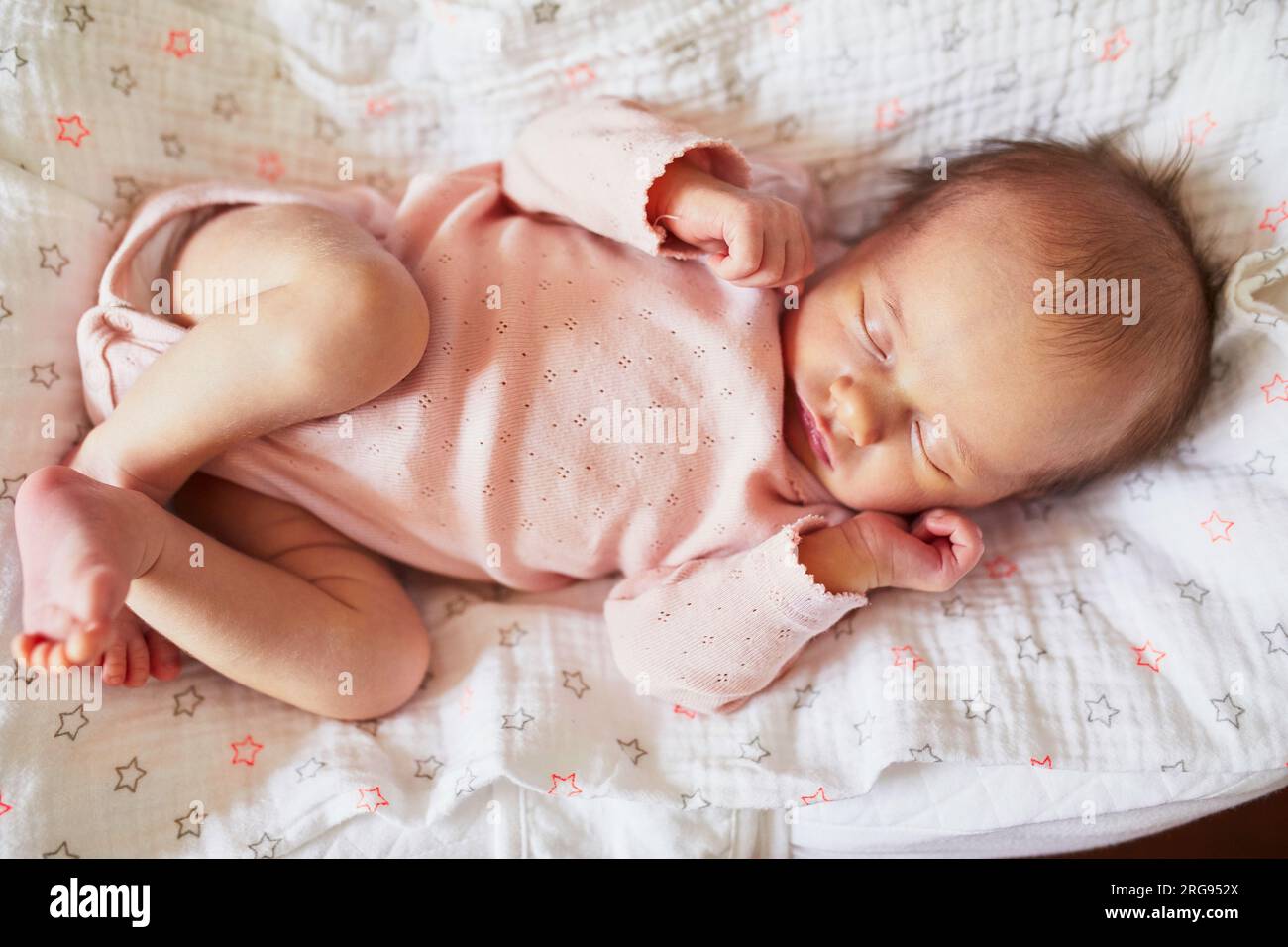 Adorable newborn baby girl sleeping in bed at home Stock Photo - Alamy