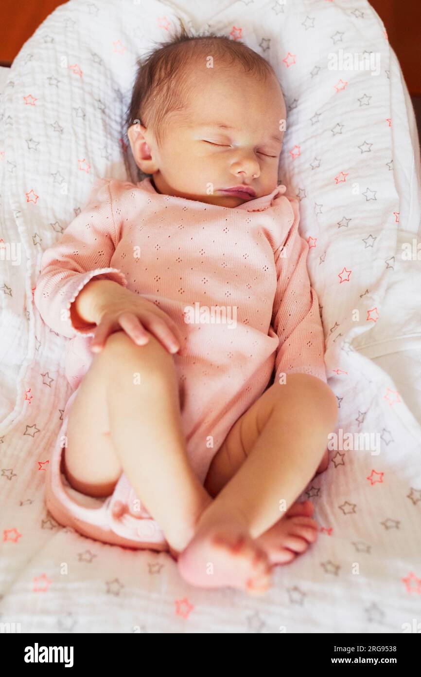 Adorable newborn baby girl sleeping in bed at home Stock Photo - Alamy