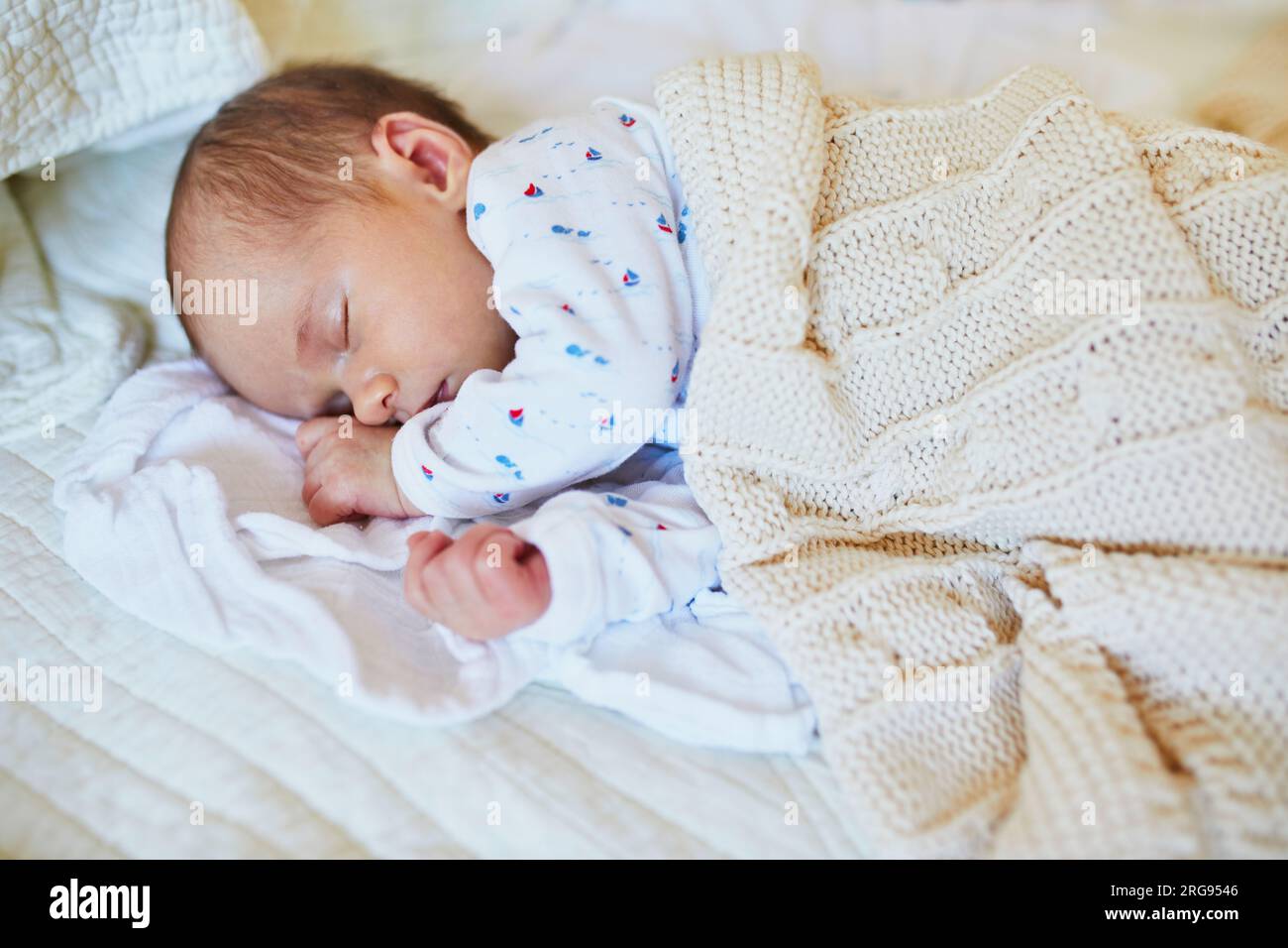 Adorable newborn baby girl sleeping in bed at home Stock Photo - Alamy