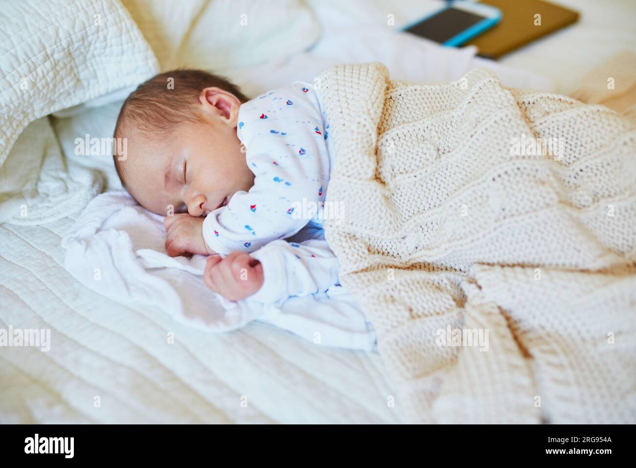 Adorable newborn baby girl sleeping in bed at home Stock Photo - Alamy