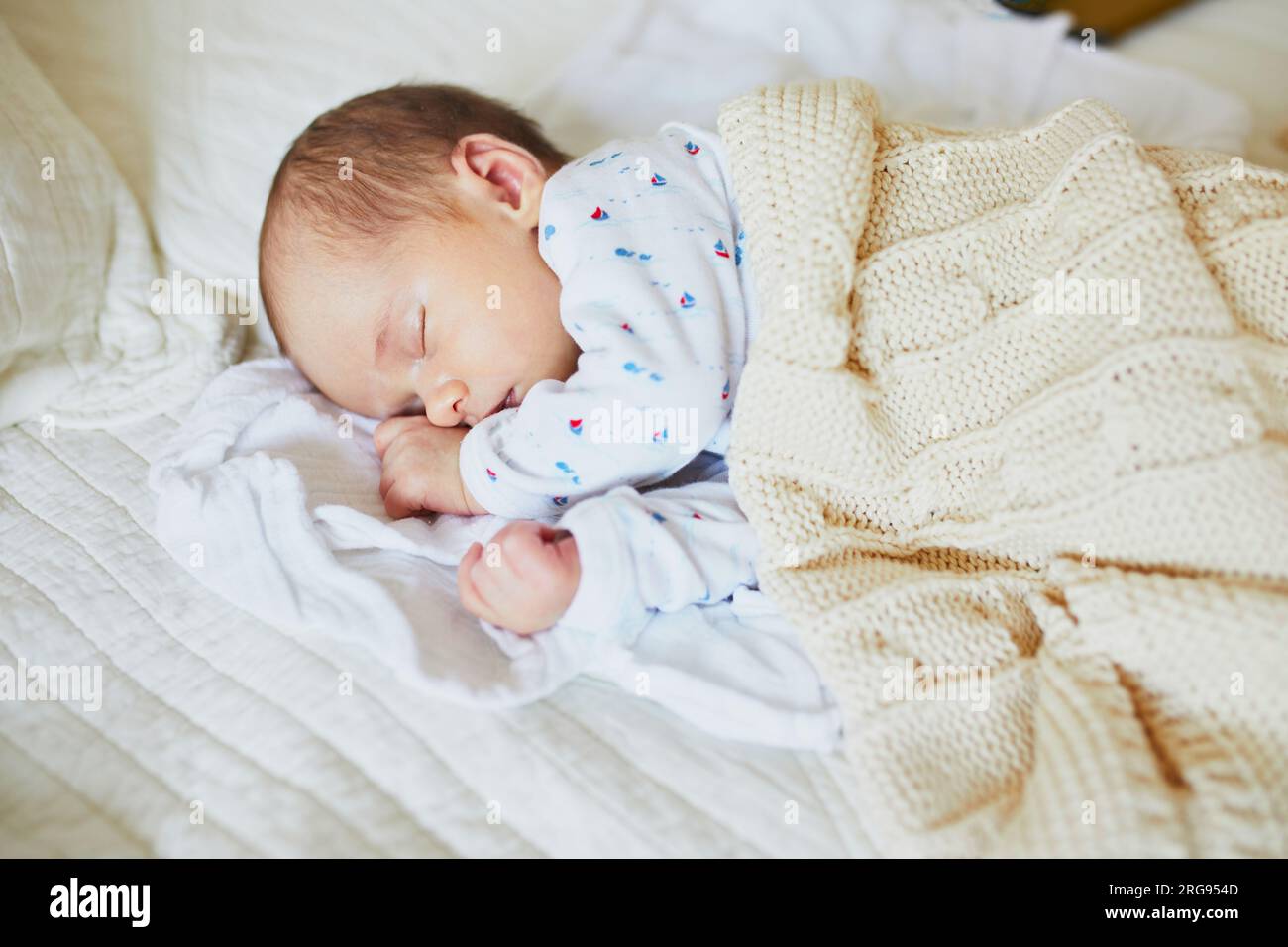 1 month old baby girl sleeping under knitted blanket. Child having a ...