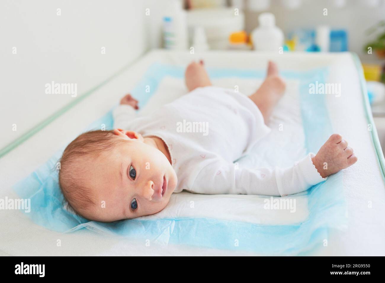 Newborn baby girl lying on changing table Stock Photo - Alamy