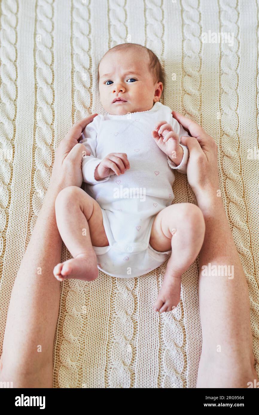Mother holding 4 weeks old baby girl in her arms. 1 month old child in ...