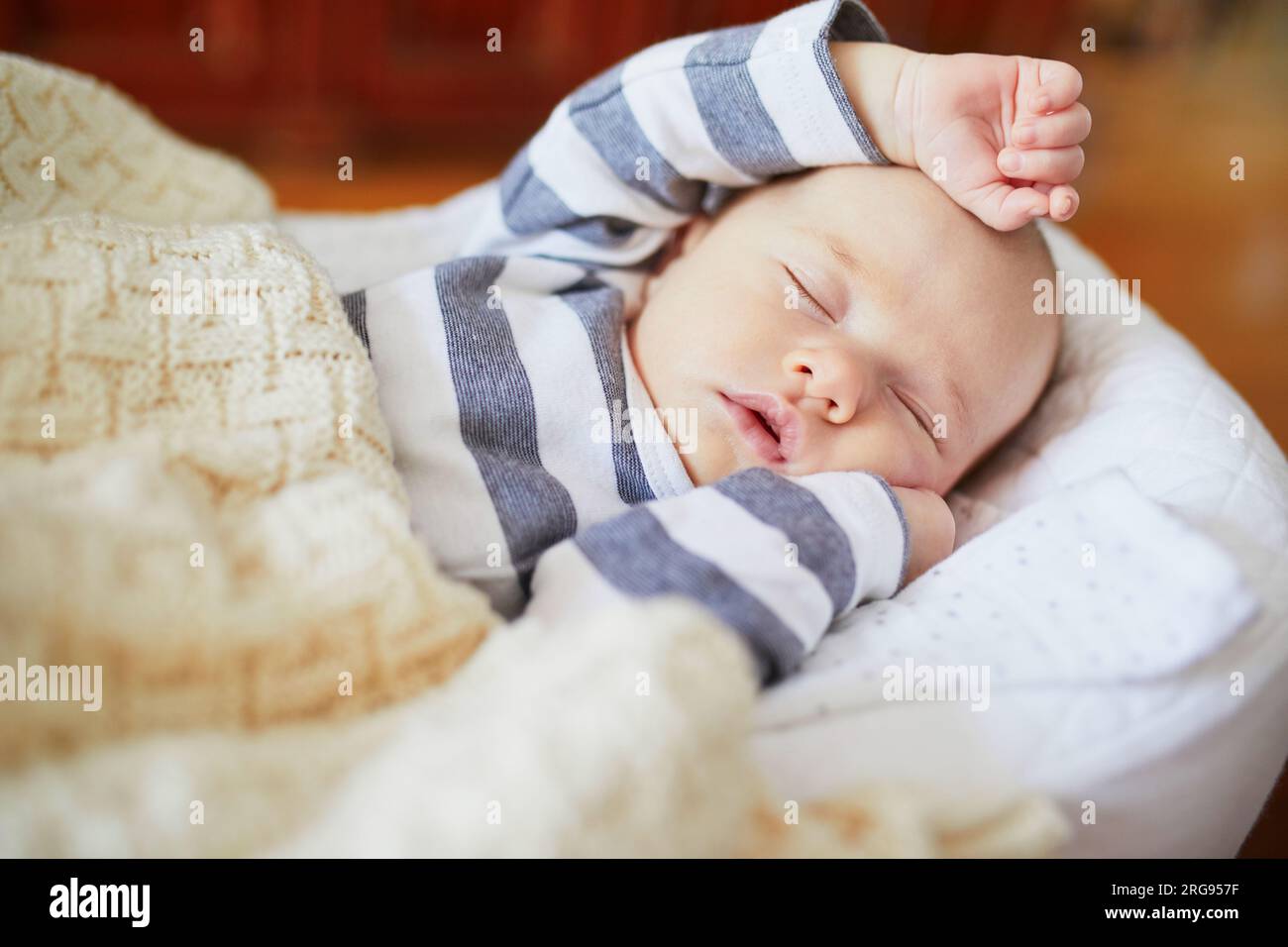 1 month old baby girl sleeping under knitted blanket. Child having a ...