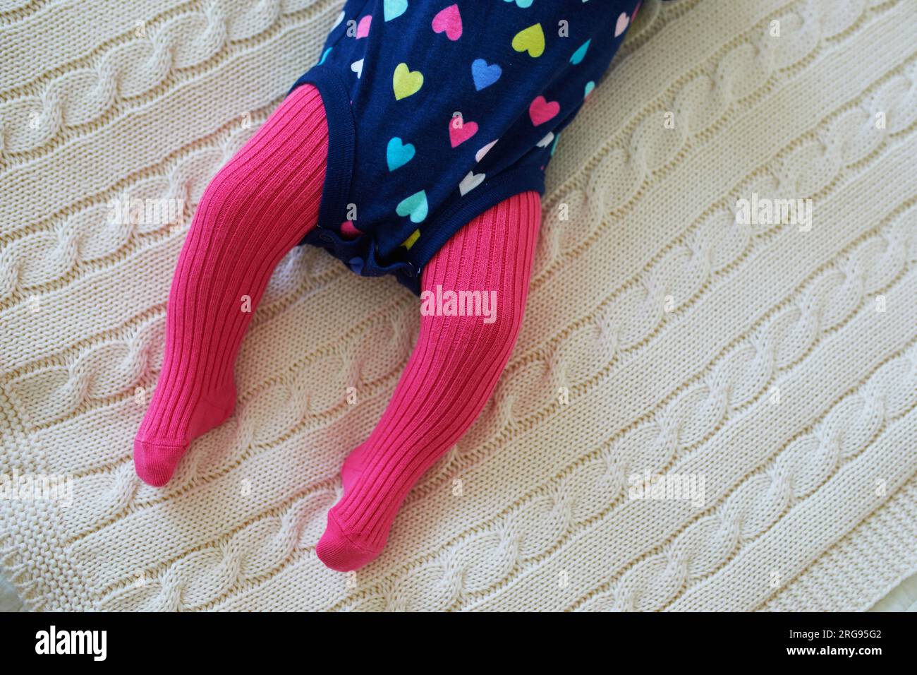 Baby girl wearing pink tights and colorful onesie. Child clothing and ...
