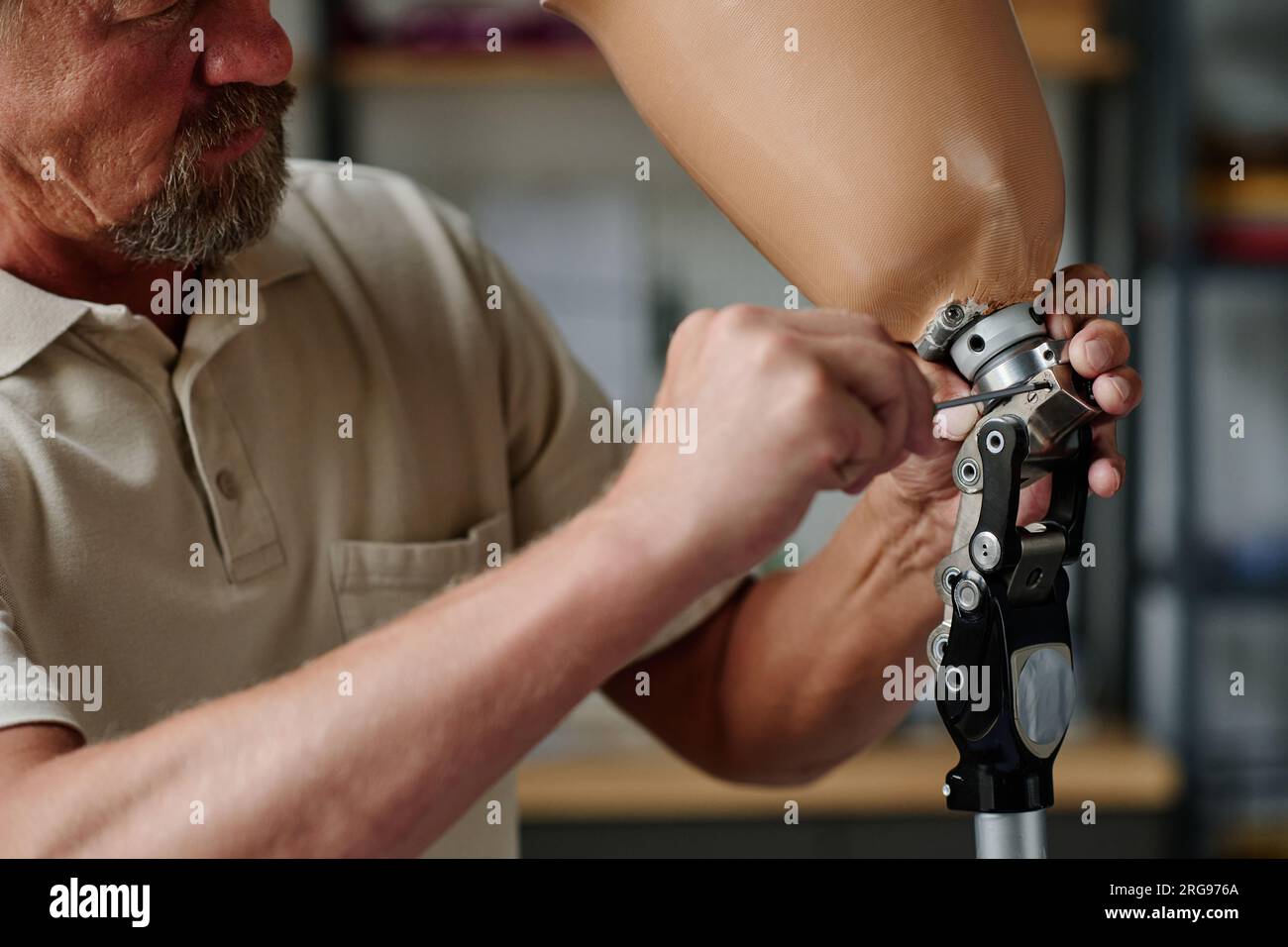 Closeup of senior man building leg prosthetics in workshop focus on ...