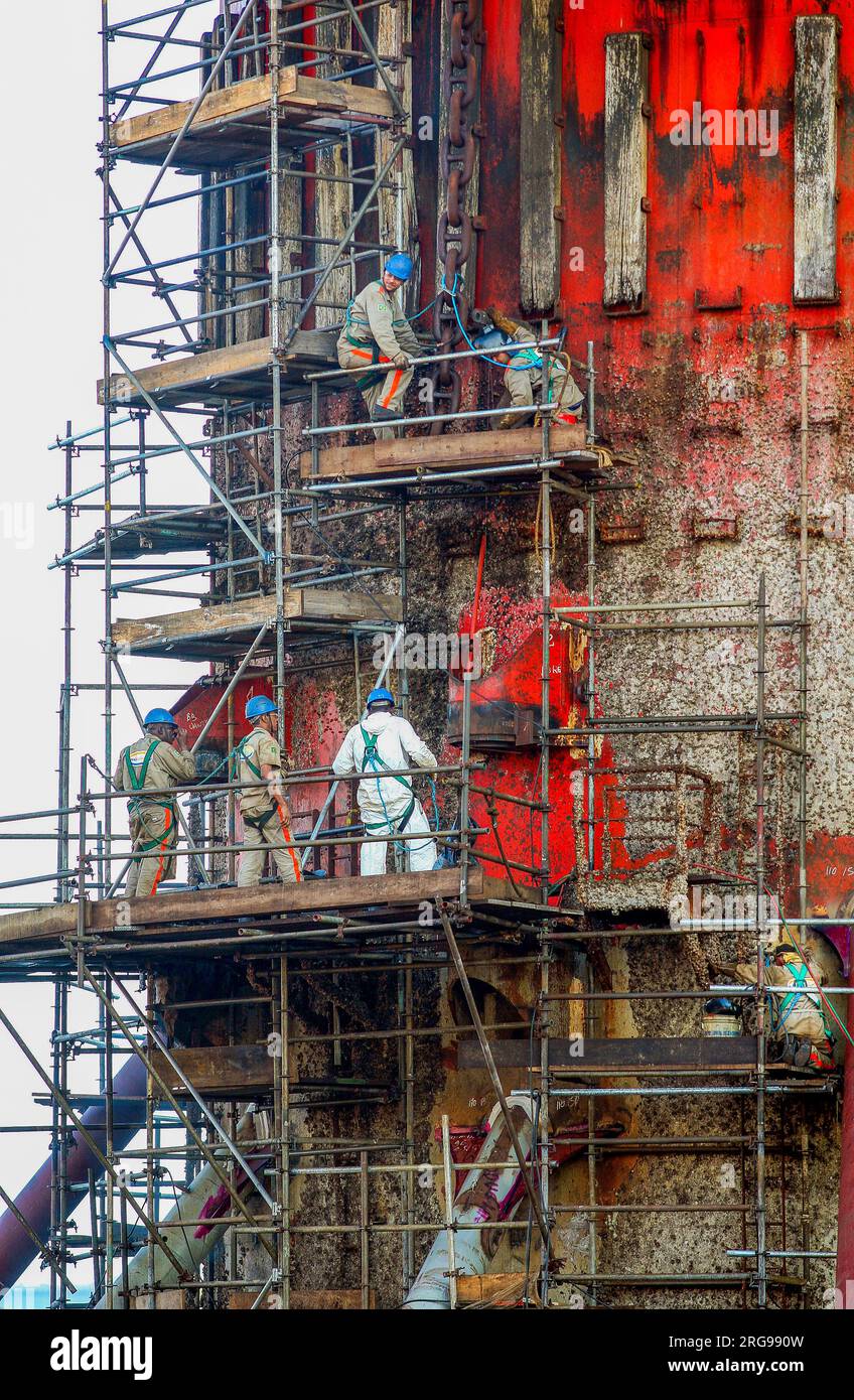 Brazil, Niteroi in Rio de Janeiro state. Workers paint a ship on Maua ...