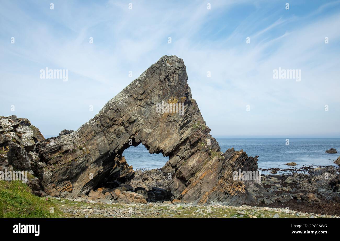 Large triangular rock formation with hole in the middle and sea ...