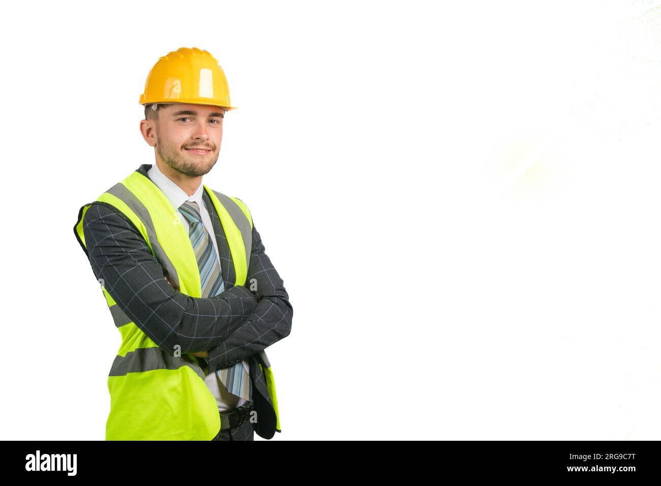 Portrait of a business man in a suit, with a hi-vis vest & hardhat ...