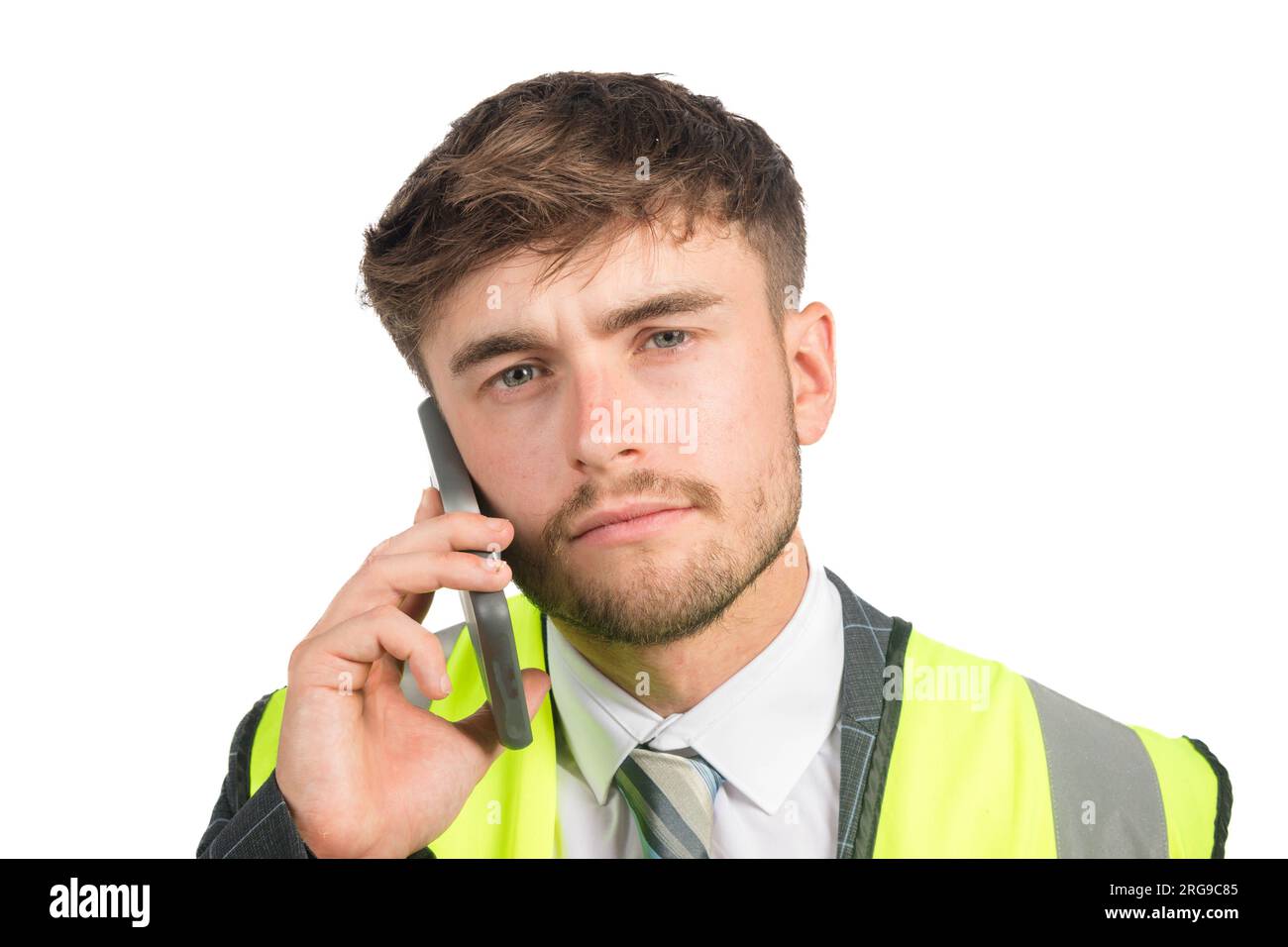 Portrait of a serious business man in a suit, with a hi-vis vest using ...