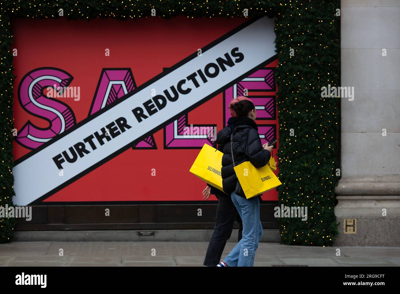 Shoppers walk past a sales signage outside Selfridges store on Oxford ...