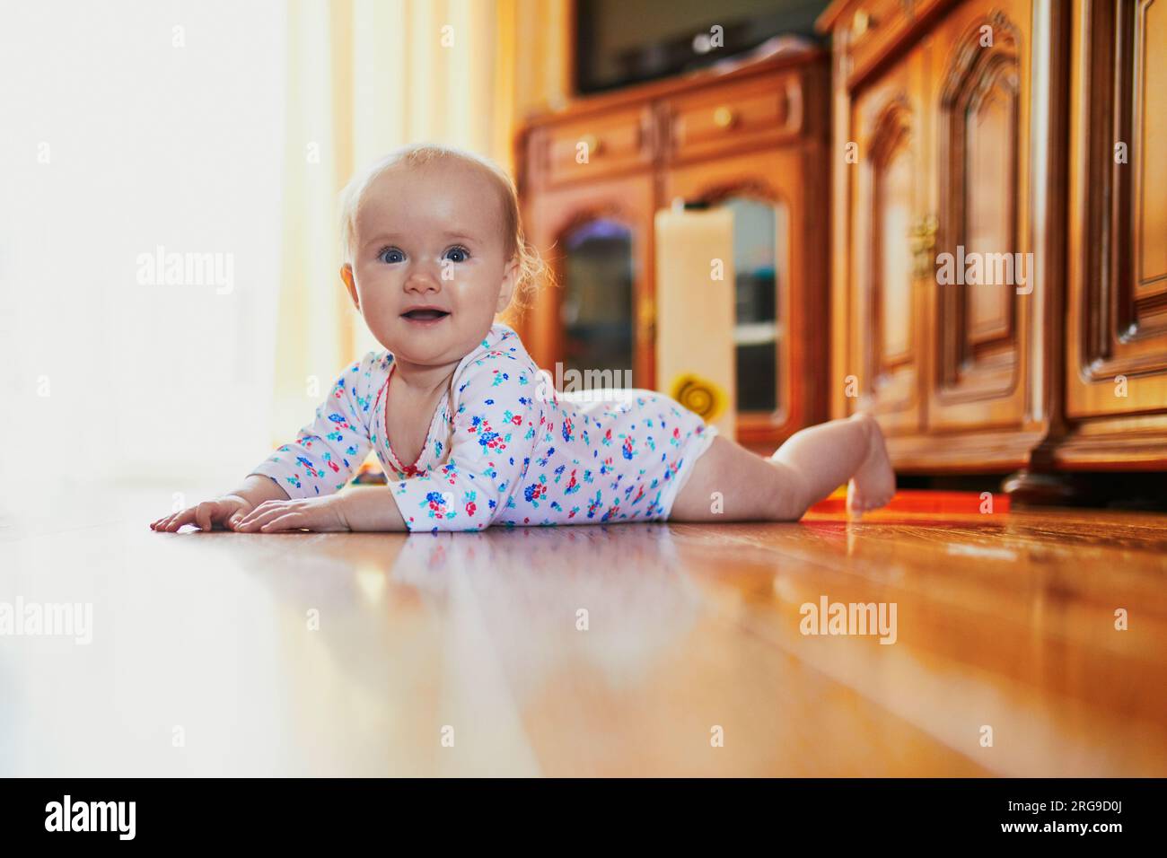 Baby girl learning to crawl. Happy healthy little child on the floor ...