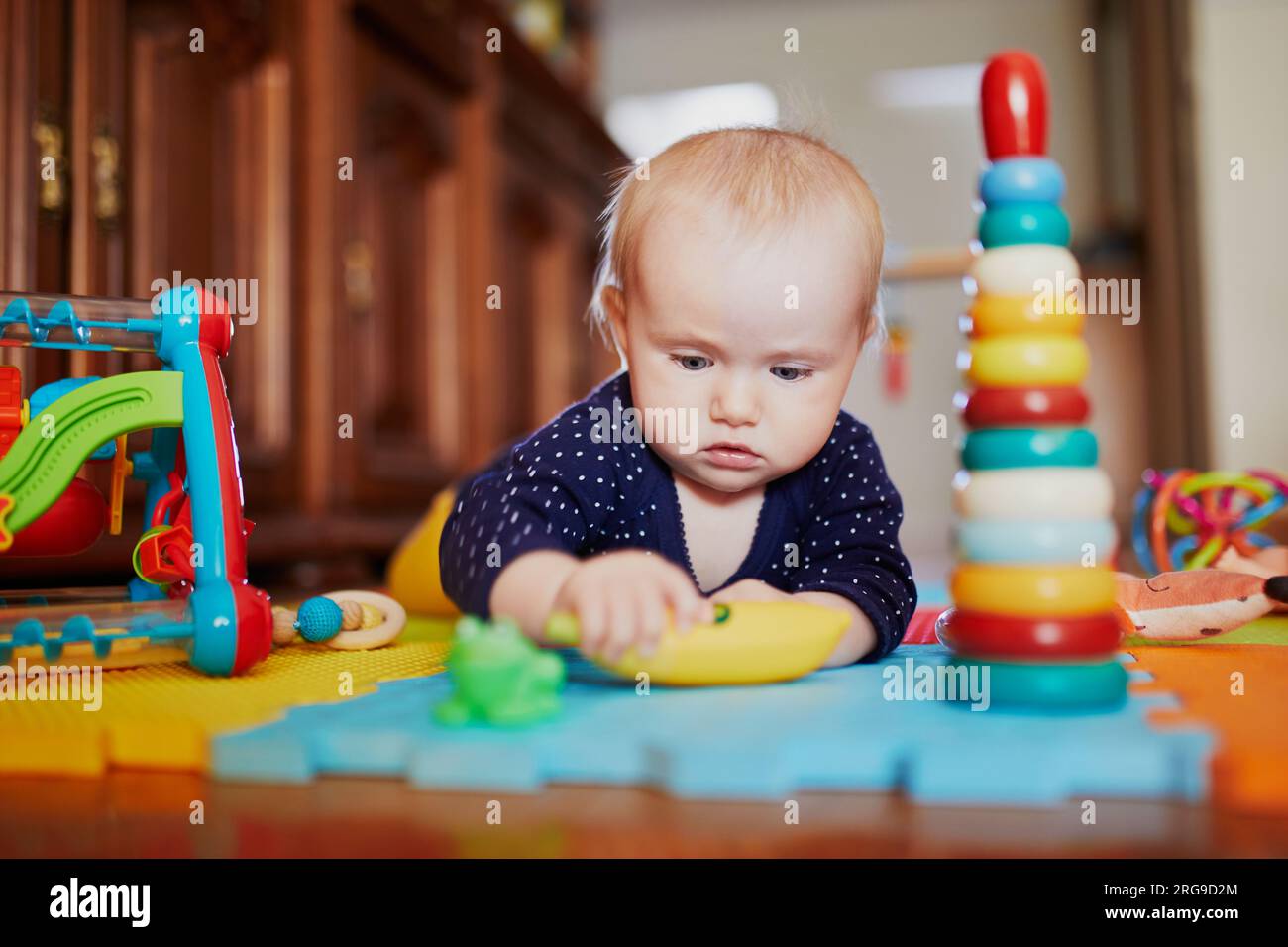 Baby girl playing on tummy hi-res stock photography and images - Alamy
