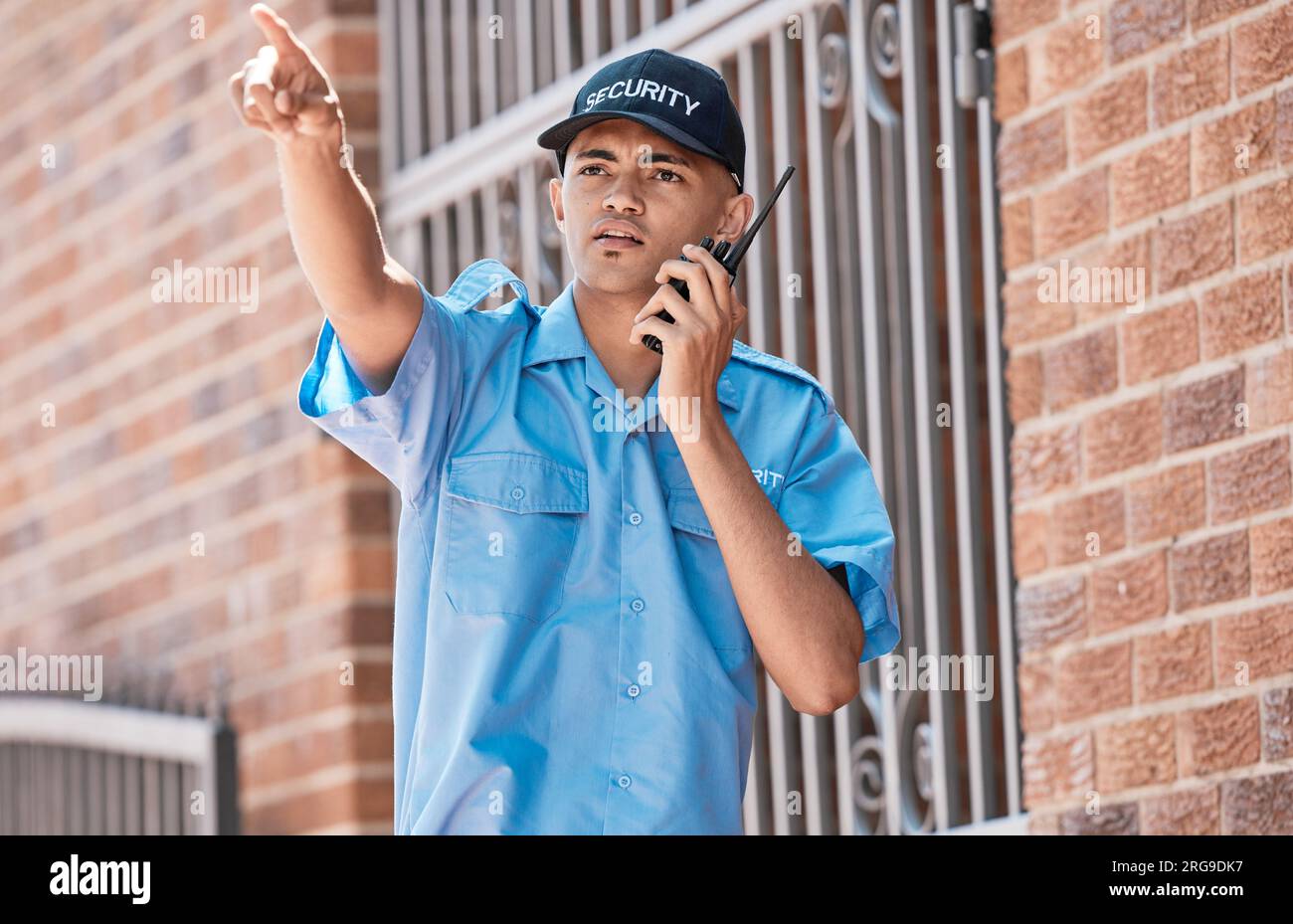 Man, walkie talkie and security guard pointing in city in communication ...