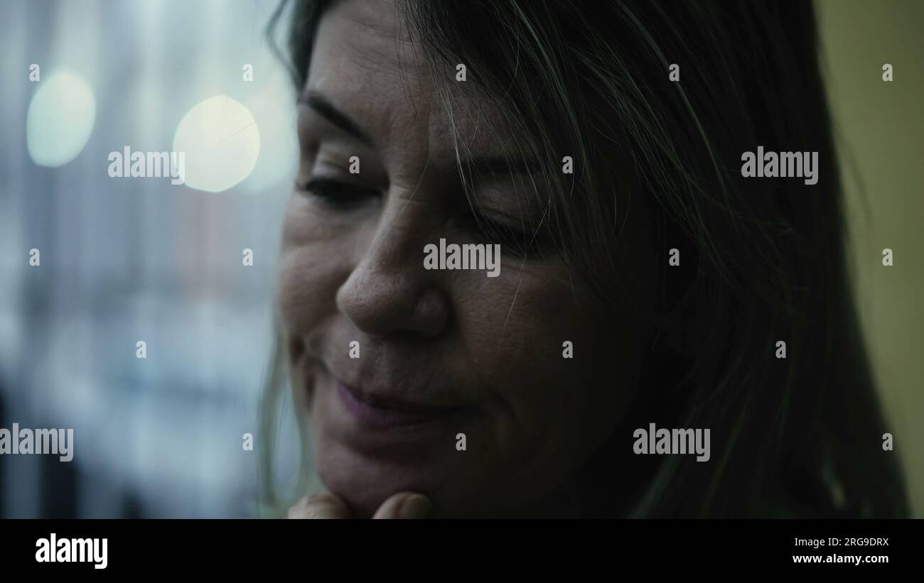 Mature woman with worried emotion, close-up face looking down in sorrow ...