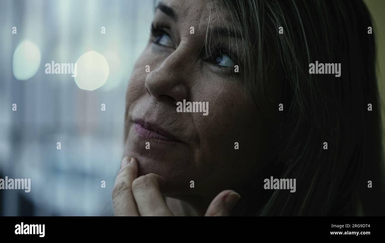 Mature woman with worried emotion, close-up face looking down in sorrow ...