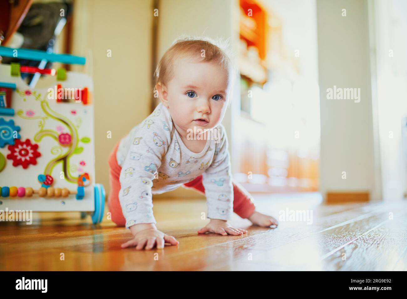 Baby girl learning to crawl. Happy healthy little child on the floor ...