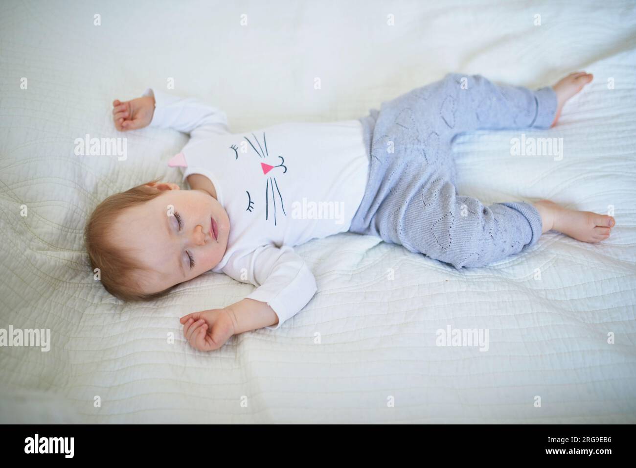 Adorable baby girl sleeping in crib. Small kid having day nap in ...