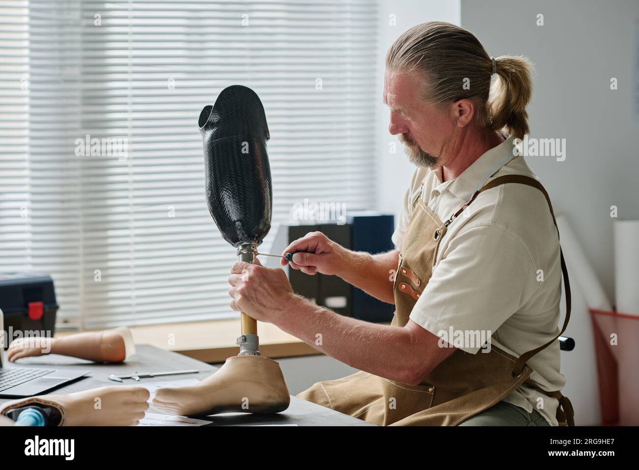 Side view portrait of craftsman building custom leg prosthetics in ...