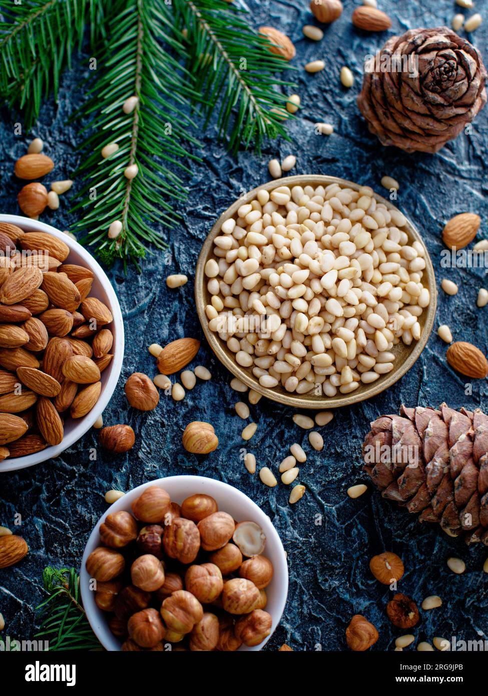 Assorted shelled nuts in bowls. Hazelnuts, almonds and pine nuts. Still ...