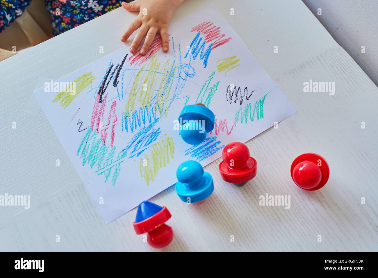 Little child drawing with wax pencils at home, in kindergaten or ...