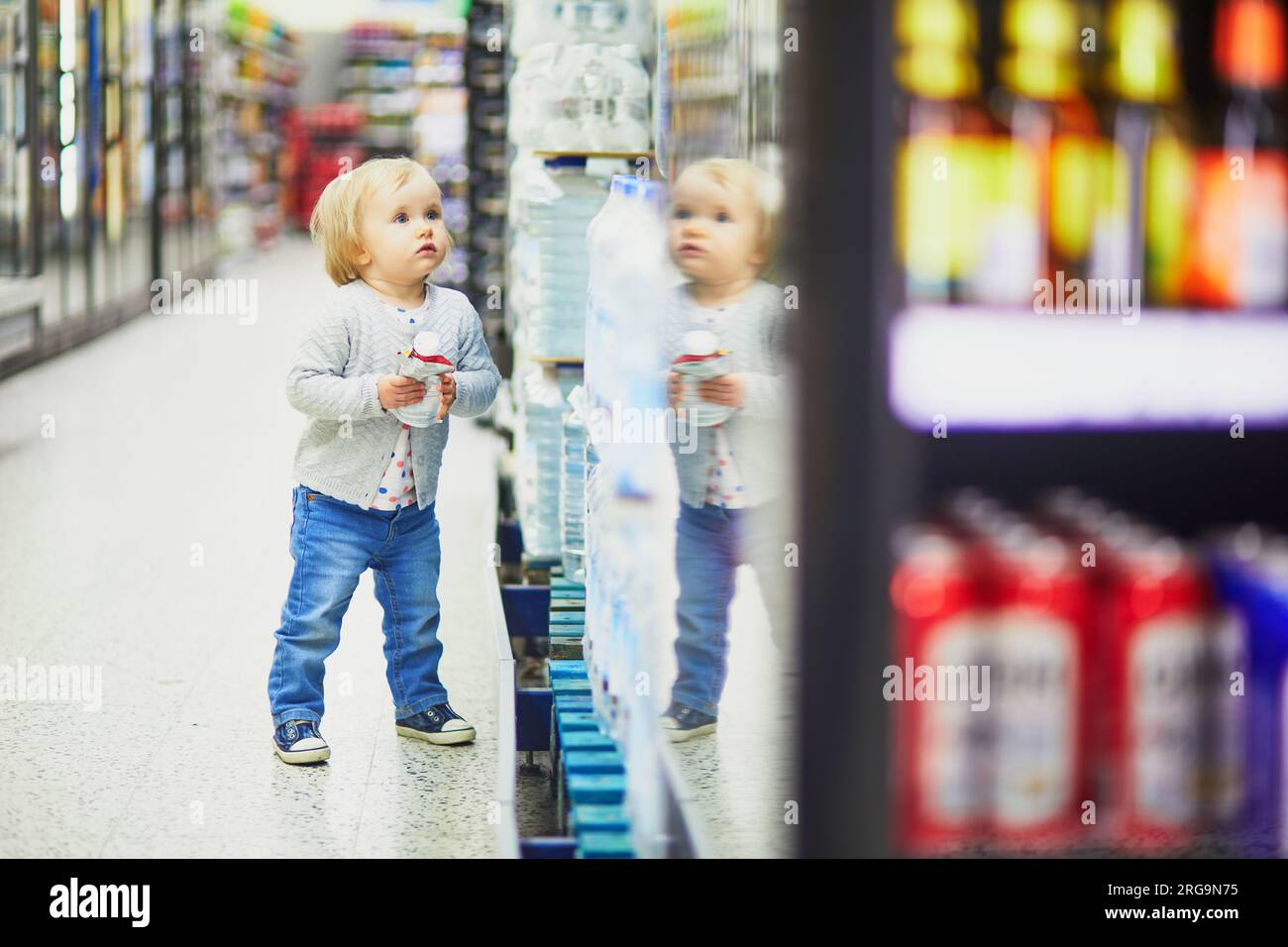 Adorable baby girl in supermarket. Little child going shopping. Kid in ...