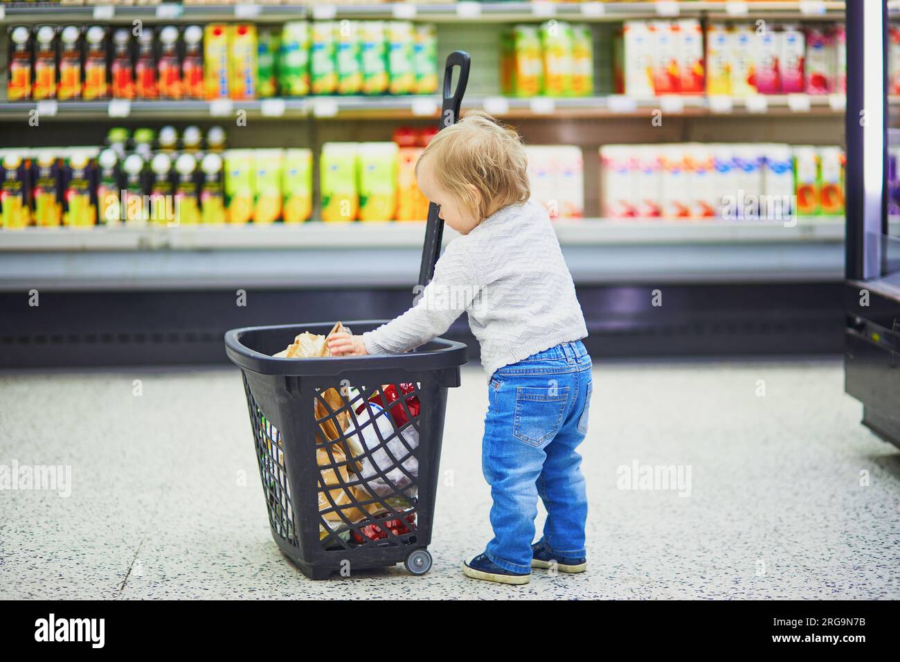 Adorable baby girl in supermarket. Little child going shopping. Kid in ...