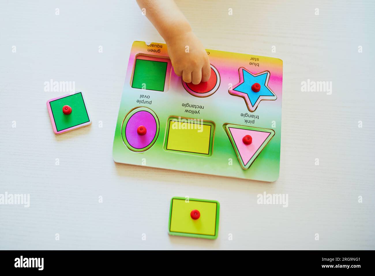 Toddler girl or boy doing wooden puzzle. Child learning geometric ...